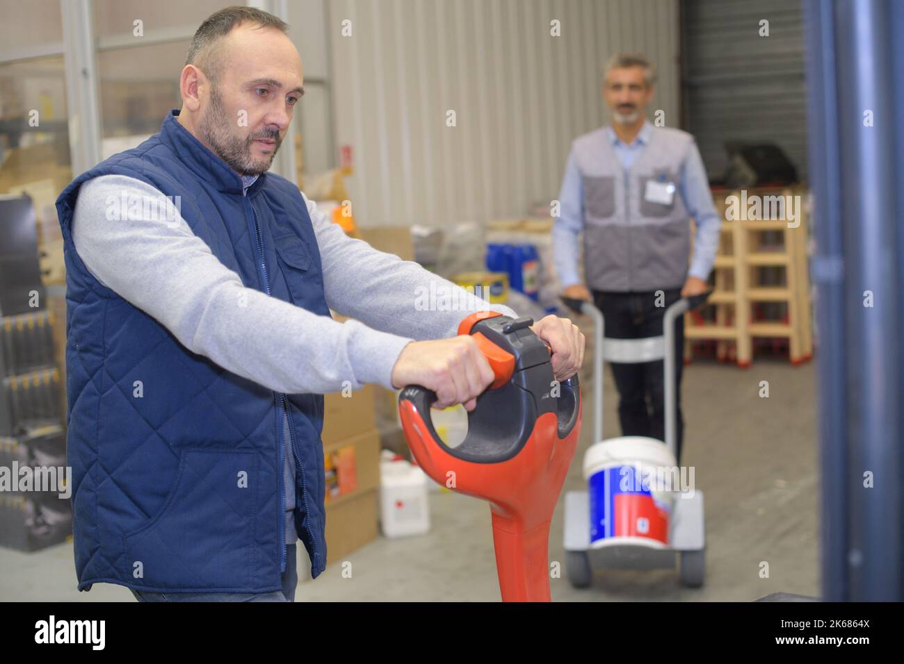 warehouse worker moving trolley in a large warehouse Stock Photo - Alamy