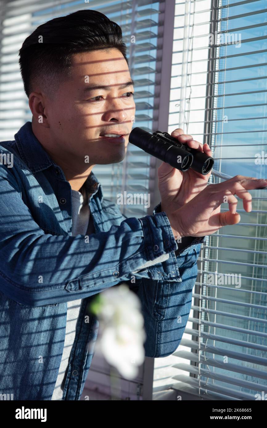 excited man spying through the window blinds with binoculars Stock ...