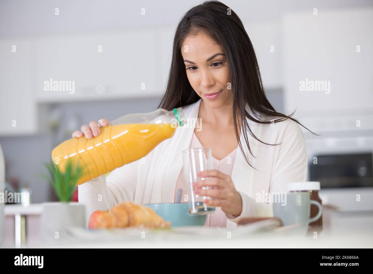 beautiful young woman pouring orange juice into glass Stock Photo - Alamy