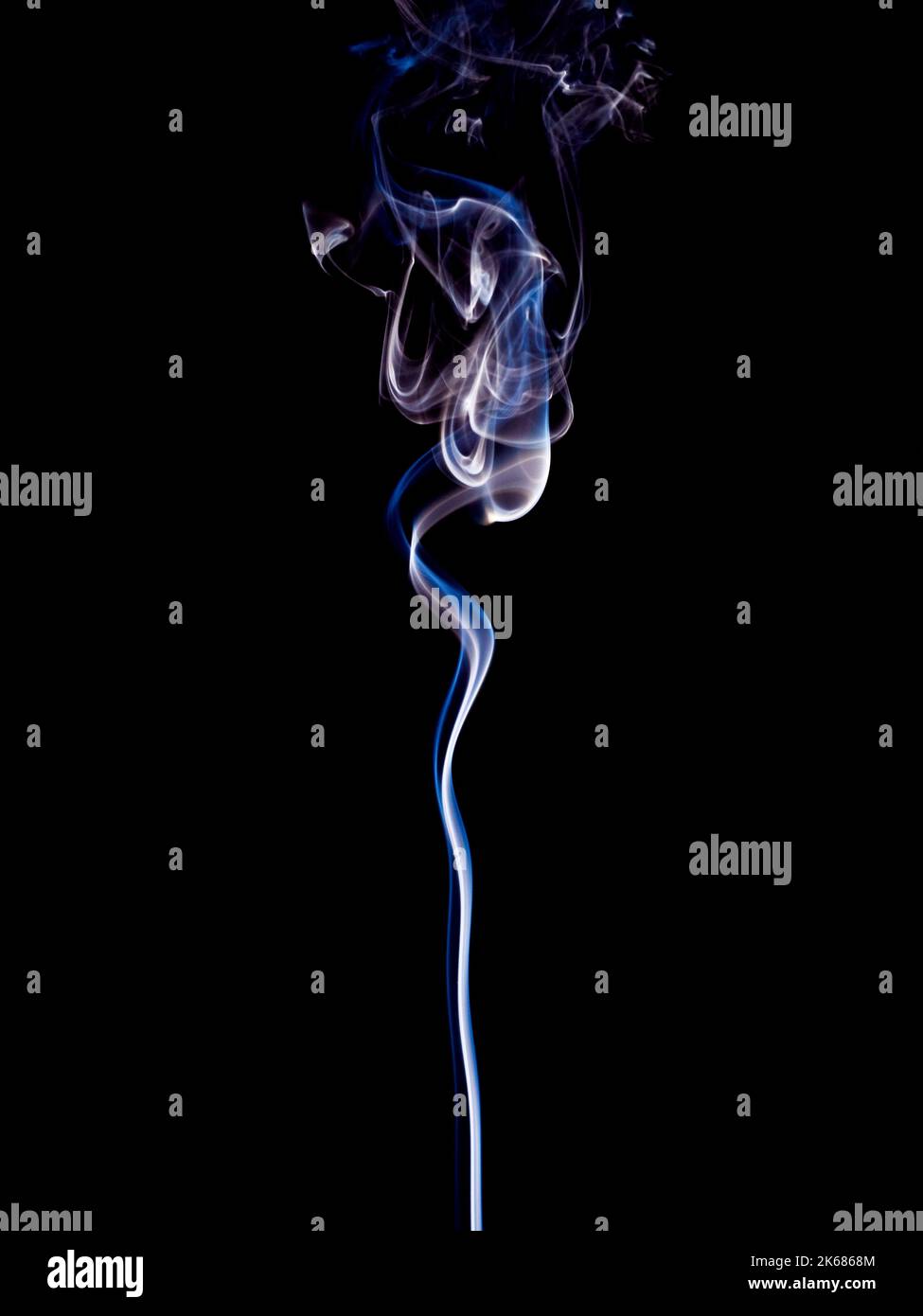 A thin stream of blue and white smoke rises gently upwards against the ...