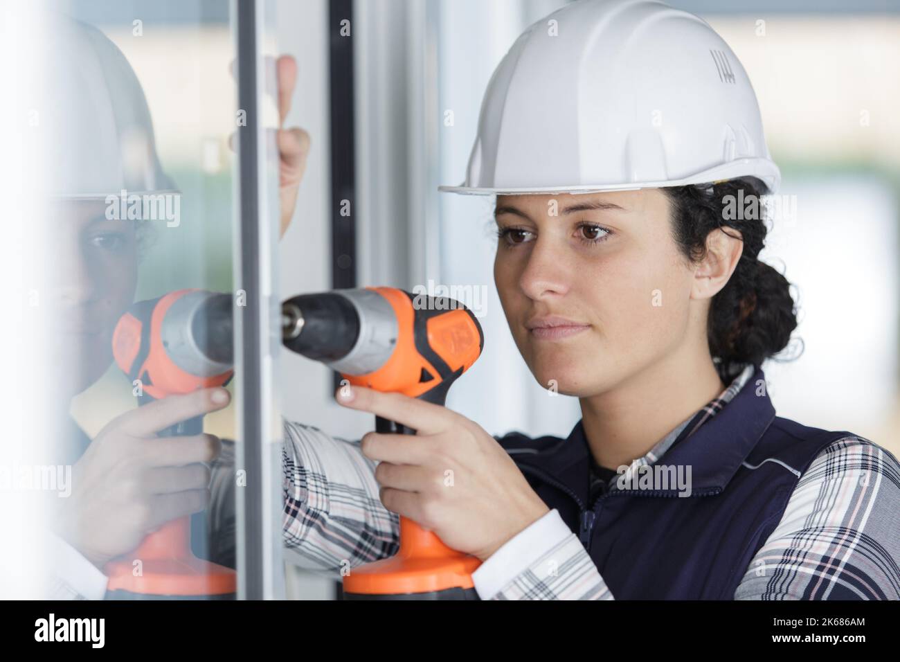 woman drilling a window in site Stock Photo - Alamy