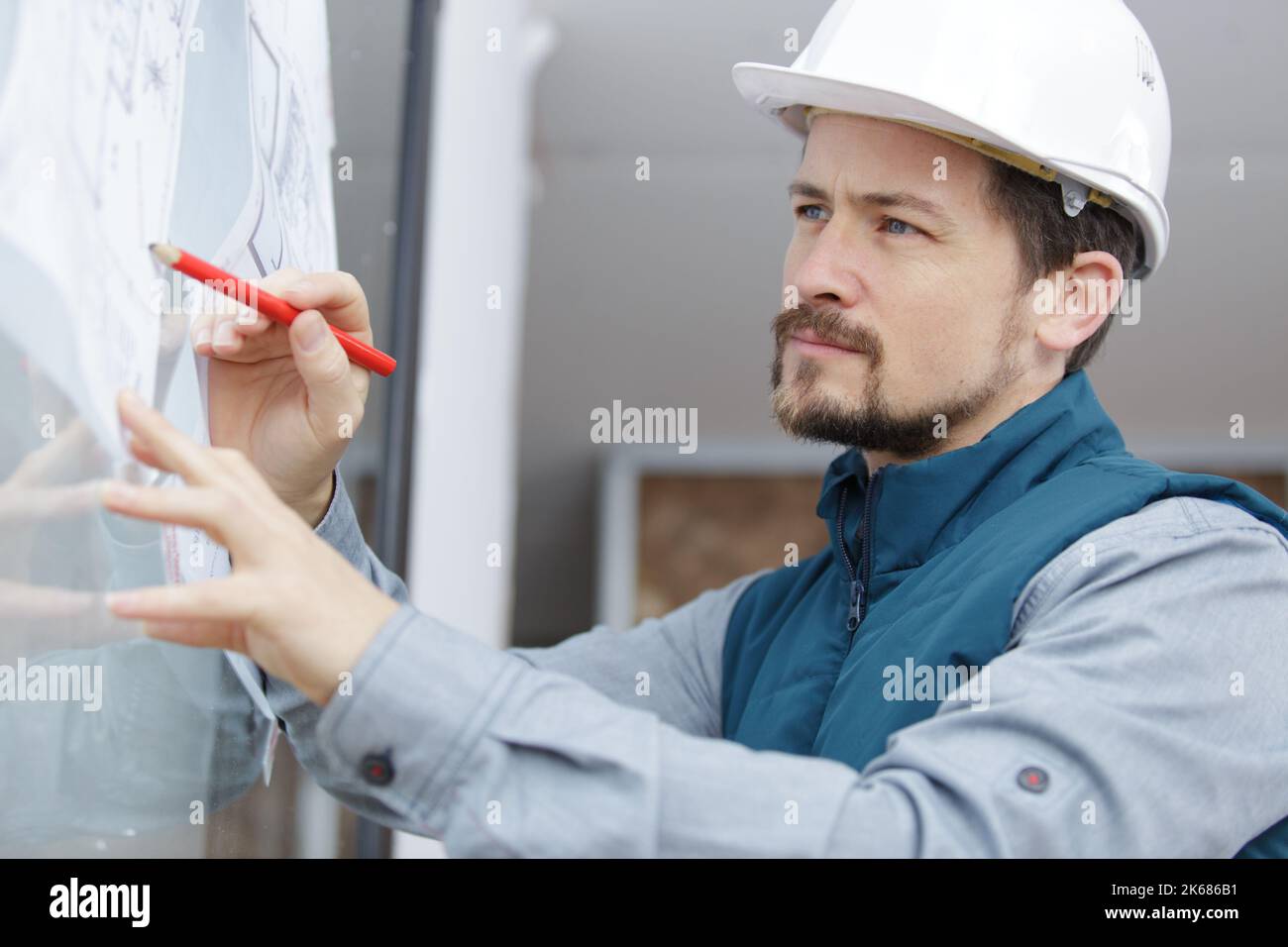 builder looking at hand drawn plan on wall Stock Photo - Alamy