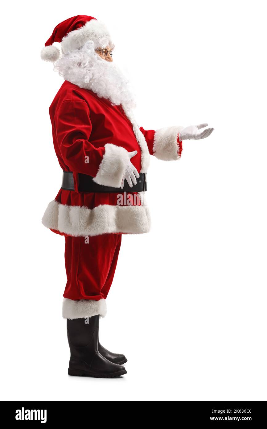 Full length profile shot of santa claus standing and waiting with arm ...