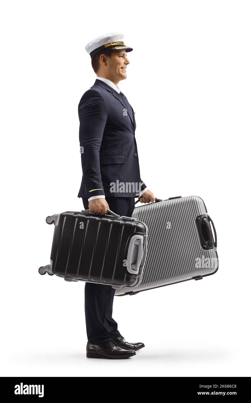 Full length profile shot of a pilot in a uniform carrying suitcases ...