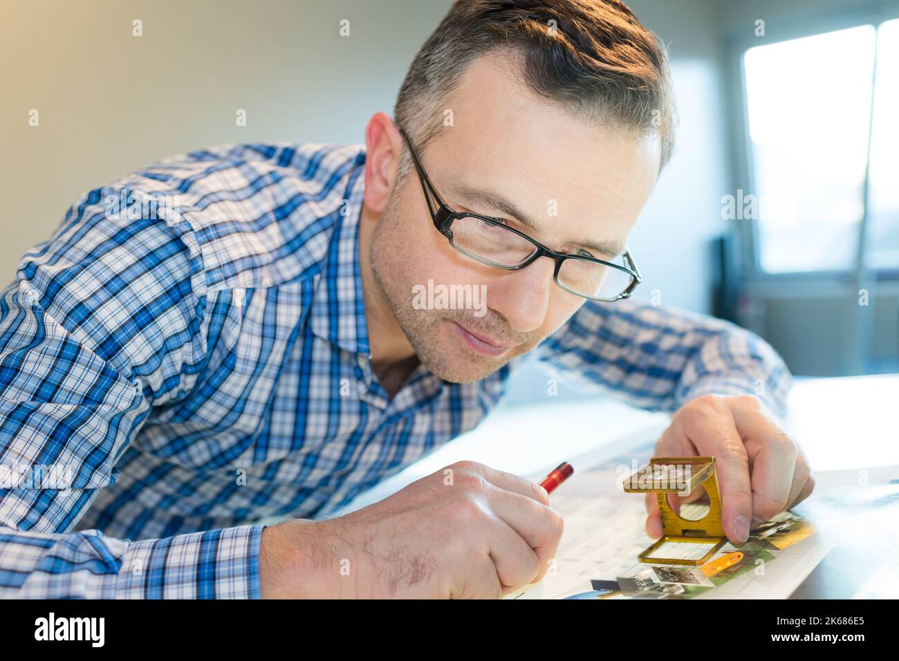 worker in printing and press centar uses a magnifying glass Stock Photo ...
