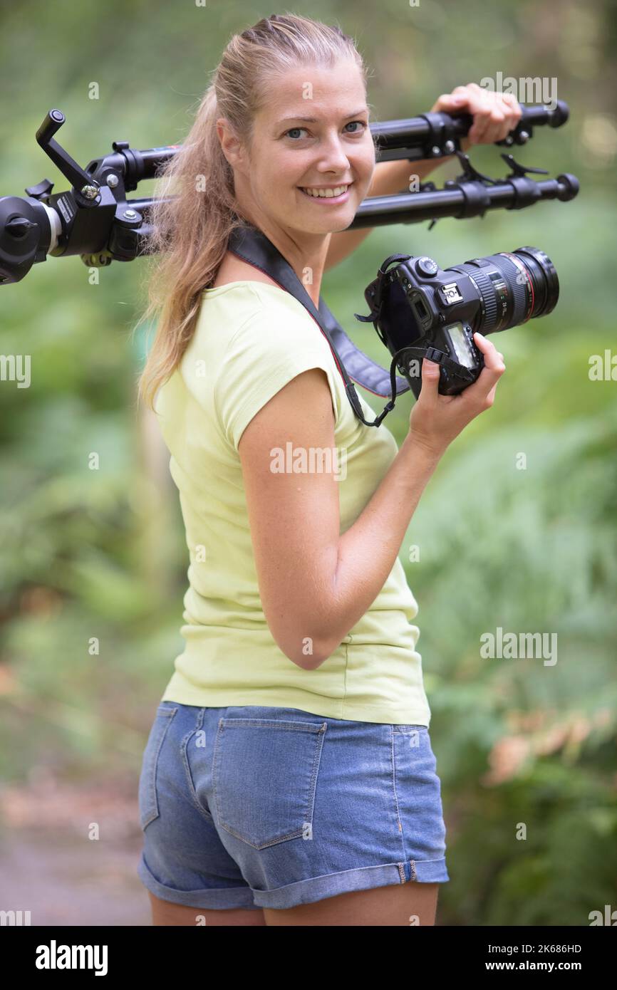 woman carrying a camera tripodin the countryside Stock Photo - Alamy