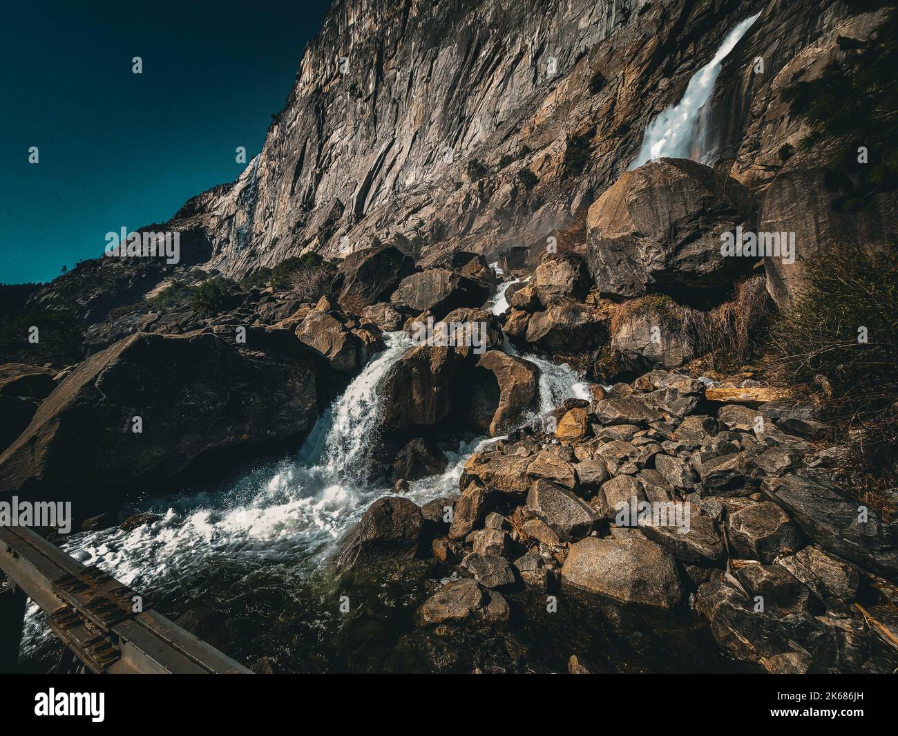 A beautiful scenery of a waterfall flowing down the rocks in sunny ...