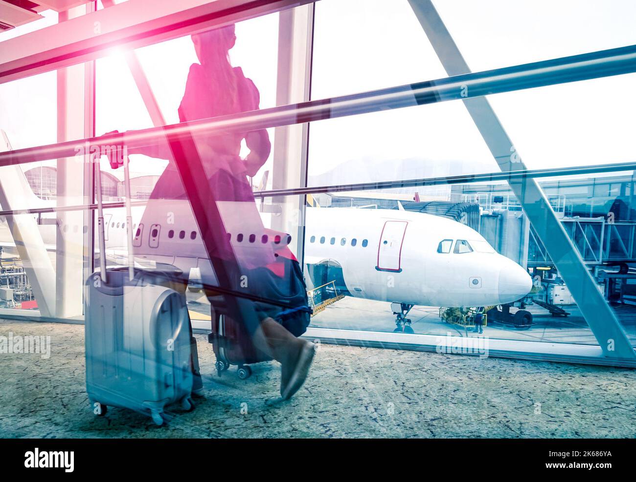 Travel concept with woman and suitcase moving fast to airport terminal ...