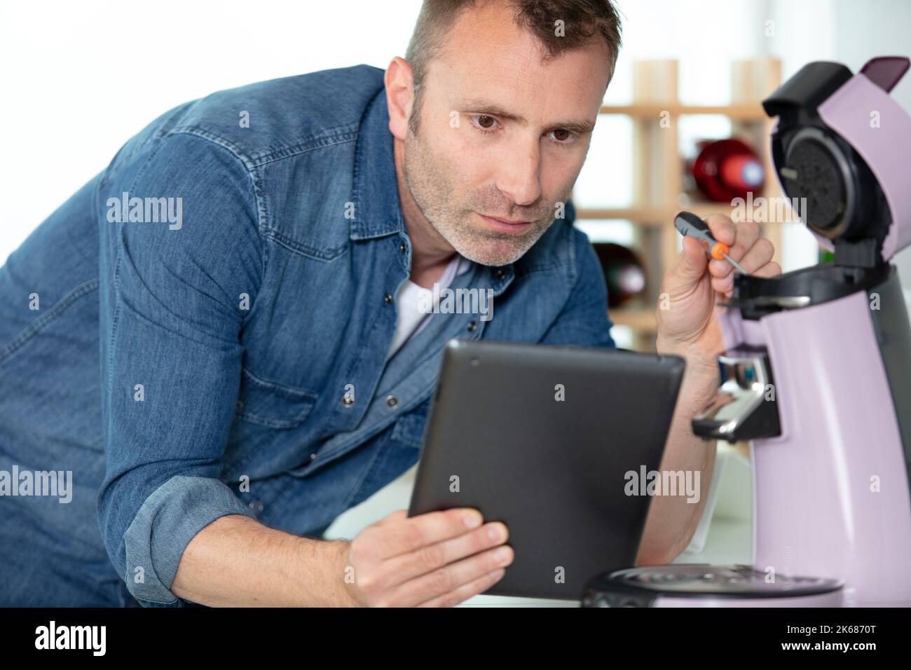 serious man repairing broken coffee machine Stock Photo - Alamy