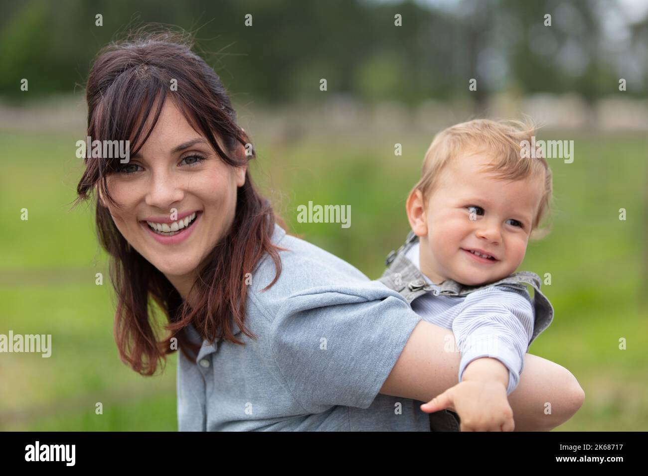 Woman giving child a piggy back ride hi-res stock photography and ...