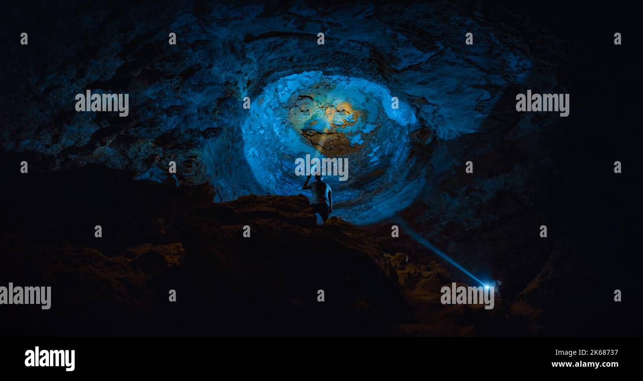 People with flashlights inside a cave Stock Photo - Alamy