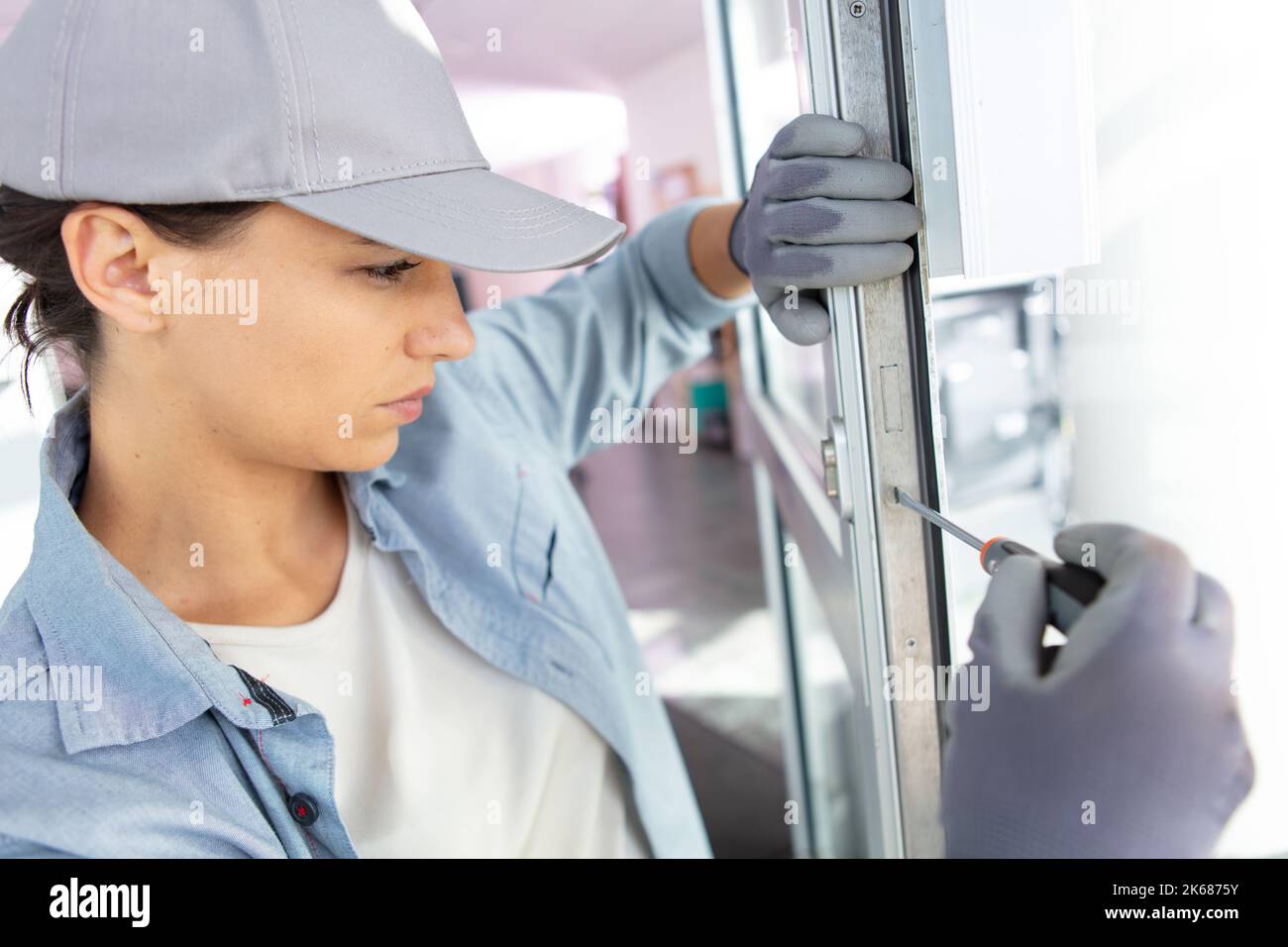 female window fitter using screwdriver Stock Photo - Alamy