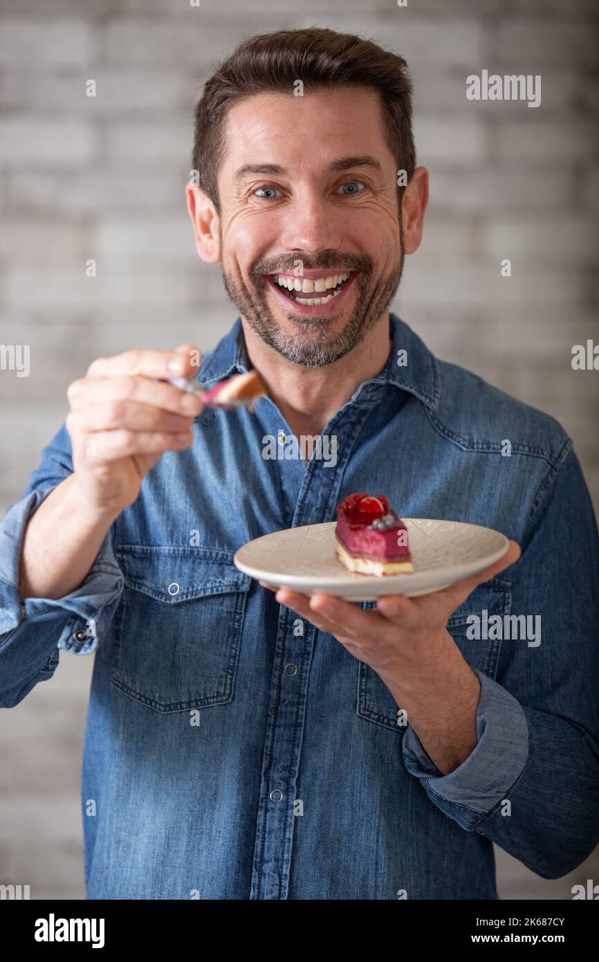man holding mini cake and offering it to the camera Stock Photo - Alamy