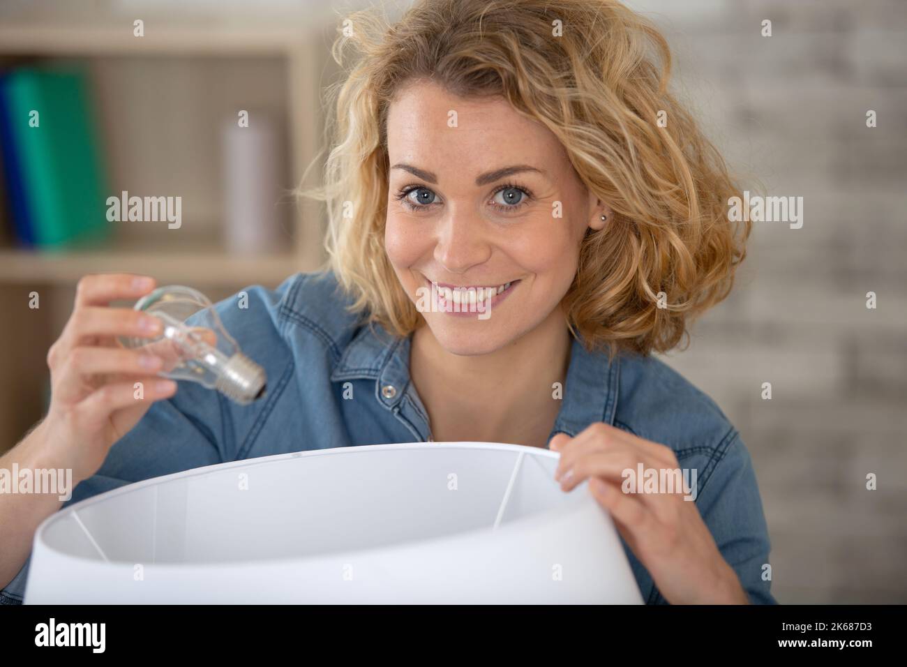 woman changing lightbulb in a lamp Stock Photo - Alamy