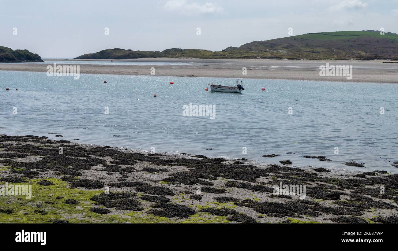 A fishing boat moored near the shore at low tide. Seaside landscape ...