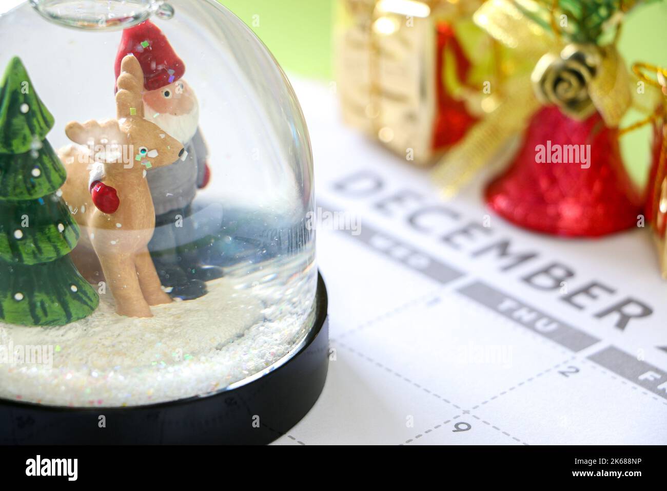 Christmas concept, close up of festive snow globe on December calendar ...