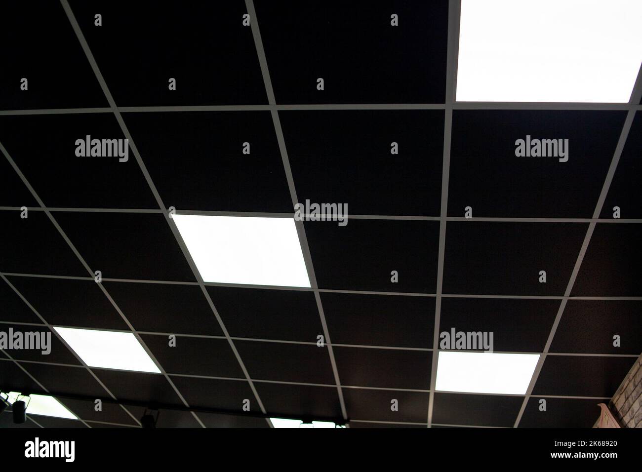 black ceiling with neon light bulbs in uprisen view. Fluorescent light ...