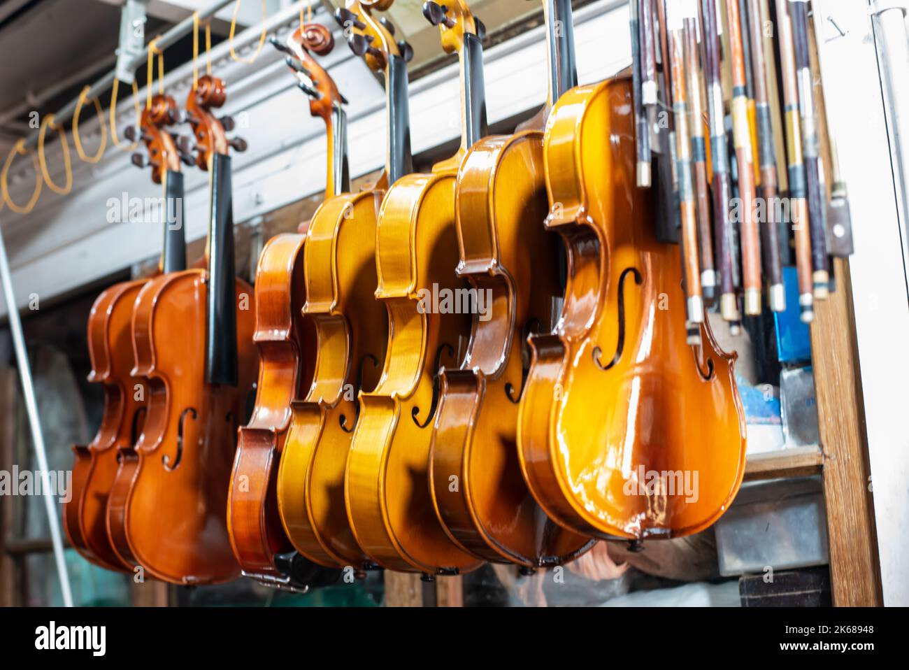 Violins are hanging in retail store to sell Stock Photo - Alamy