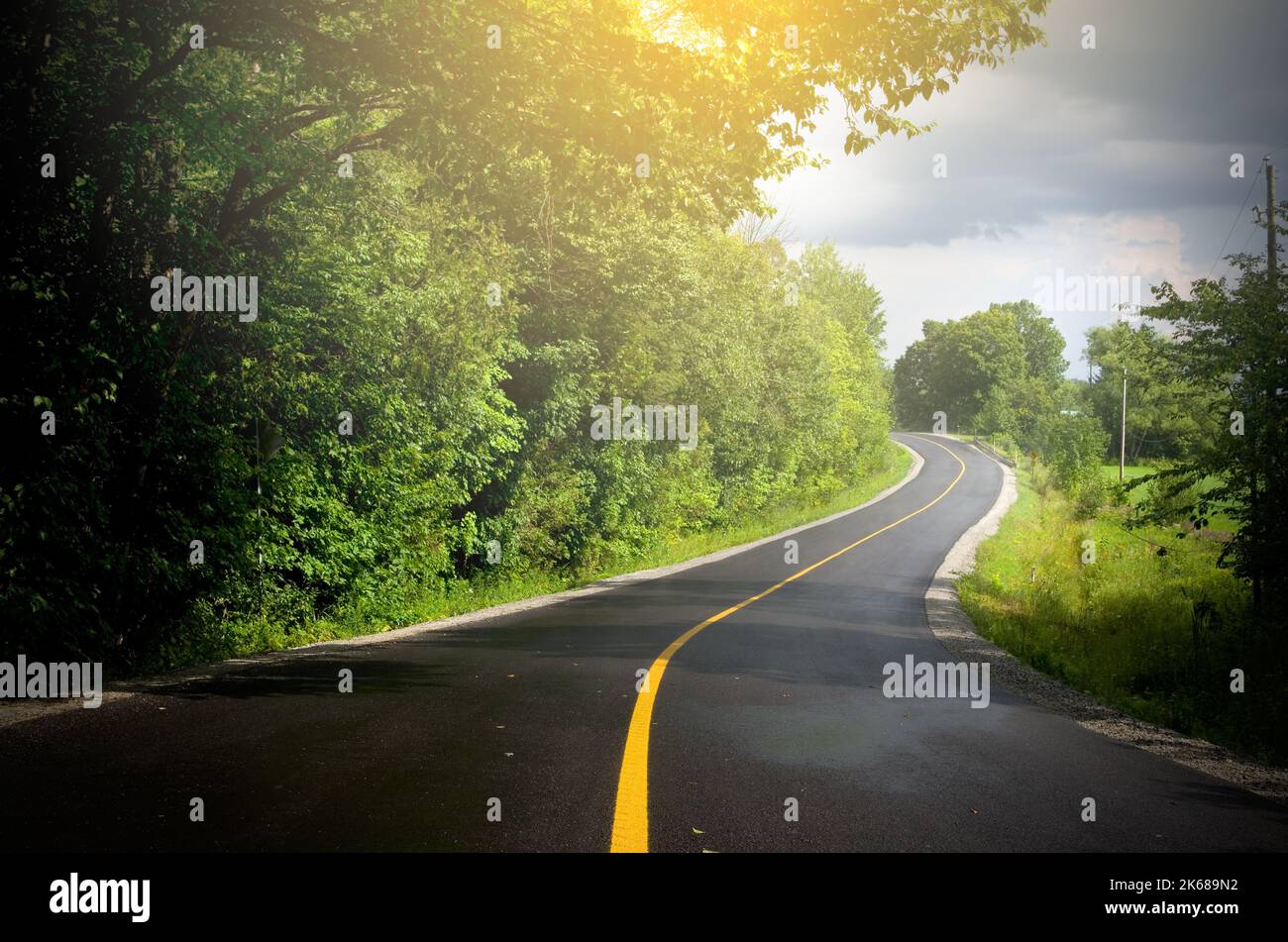Beautiful Curved Road in Rural Area with Stromy Sky and Sun Rays Stock ...