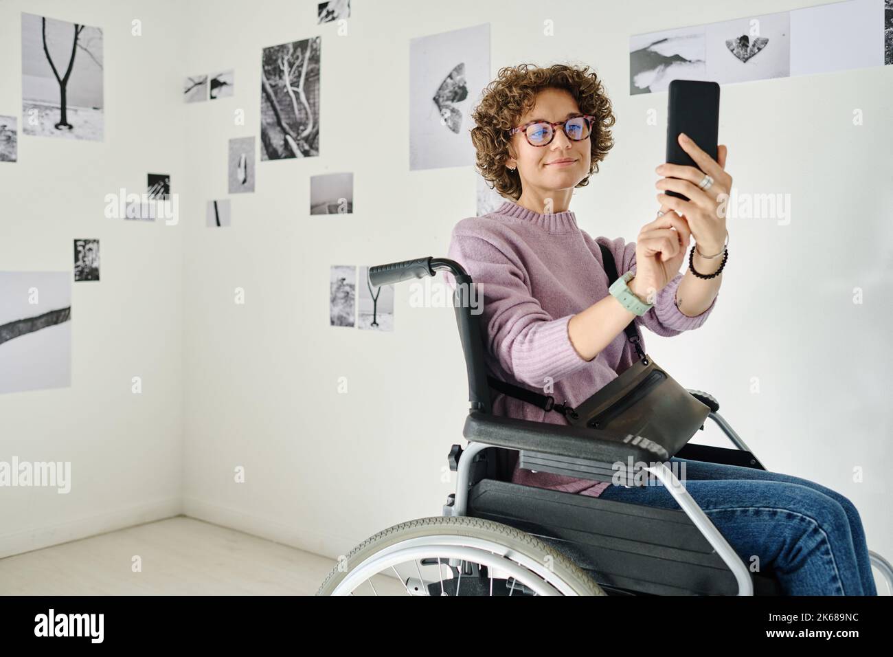 Young woman with disability using smartphone to take selfie portrait at ...