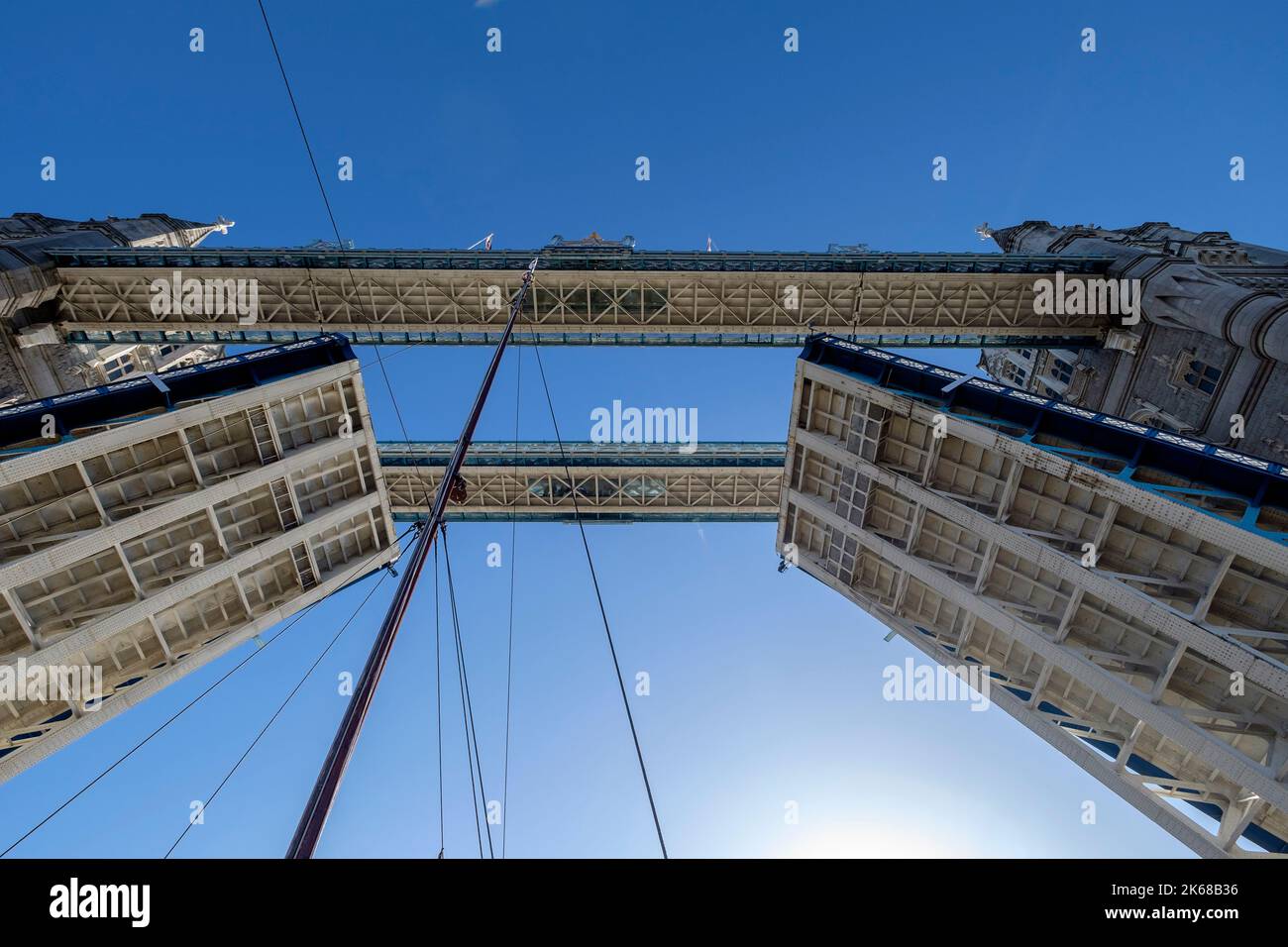 Tower Bridge raised to allow a boat with a tall mast to pass underneath ...