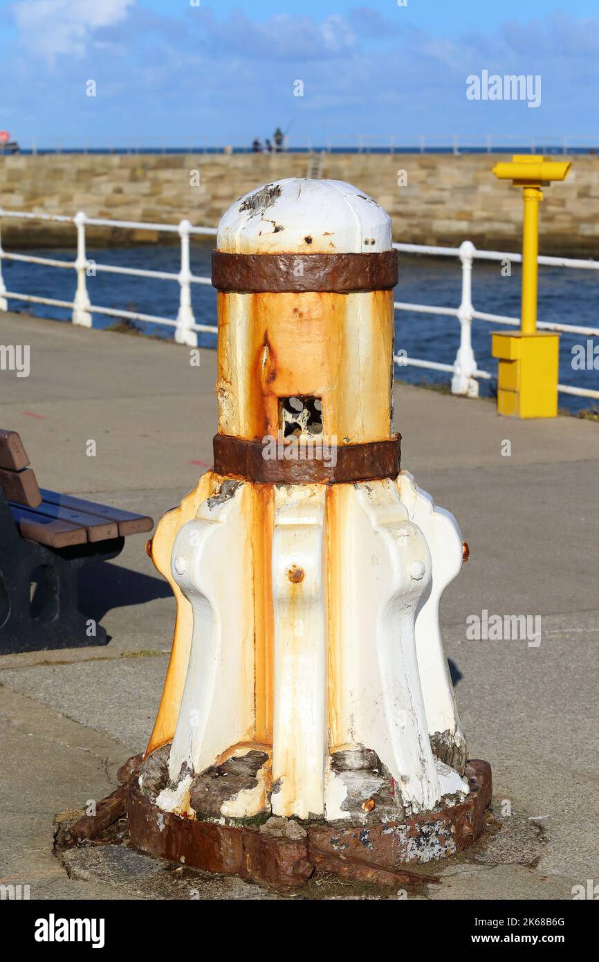 an old capstan with rust stains on whitby pier on a bright sunny day ...