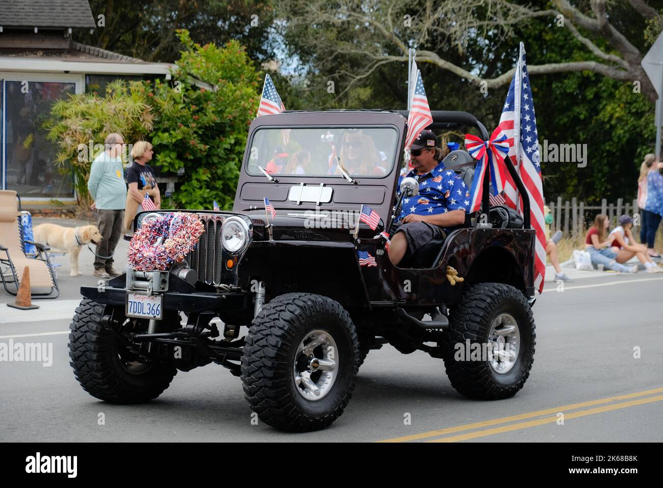 A black open-top jeep decorated with the American flag in an ...
