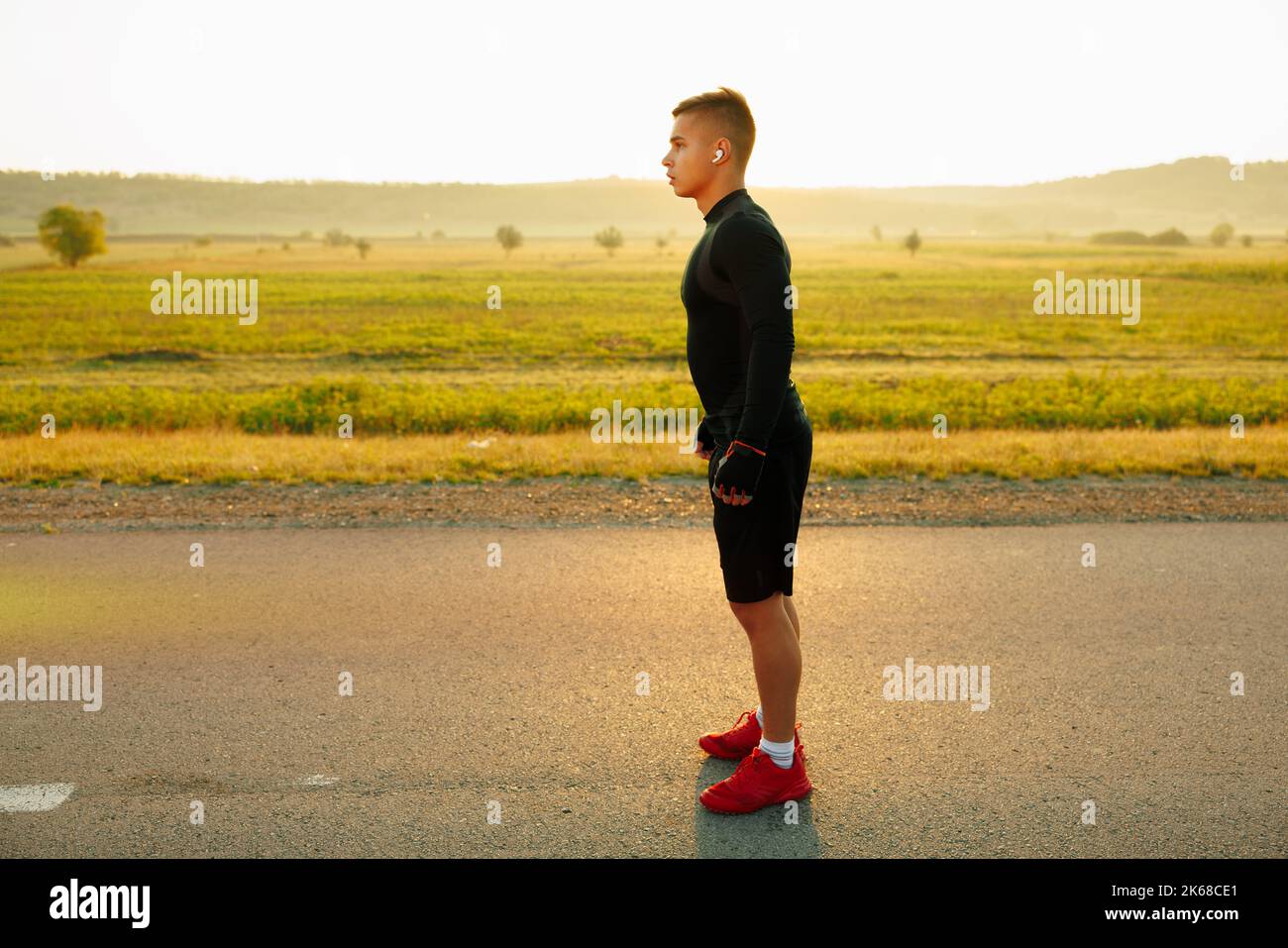 A handsome athlete takes a breath of air at the starting line before ...
