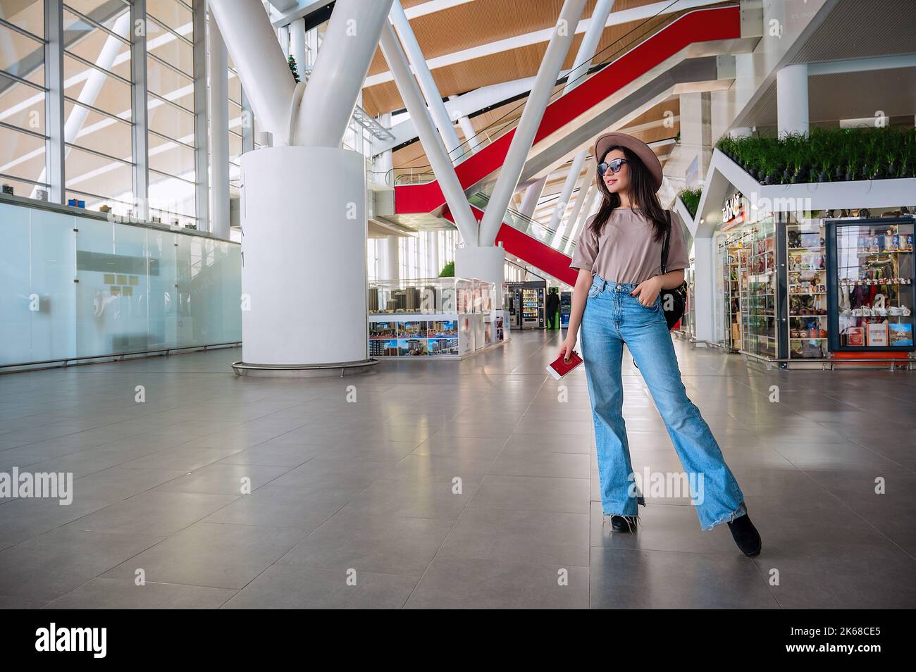 Airport passenger posing for the camera. Beautiful girl waits for a ...