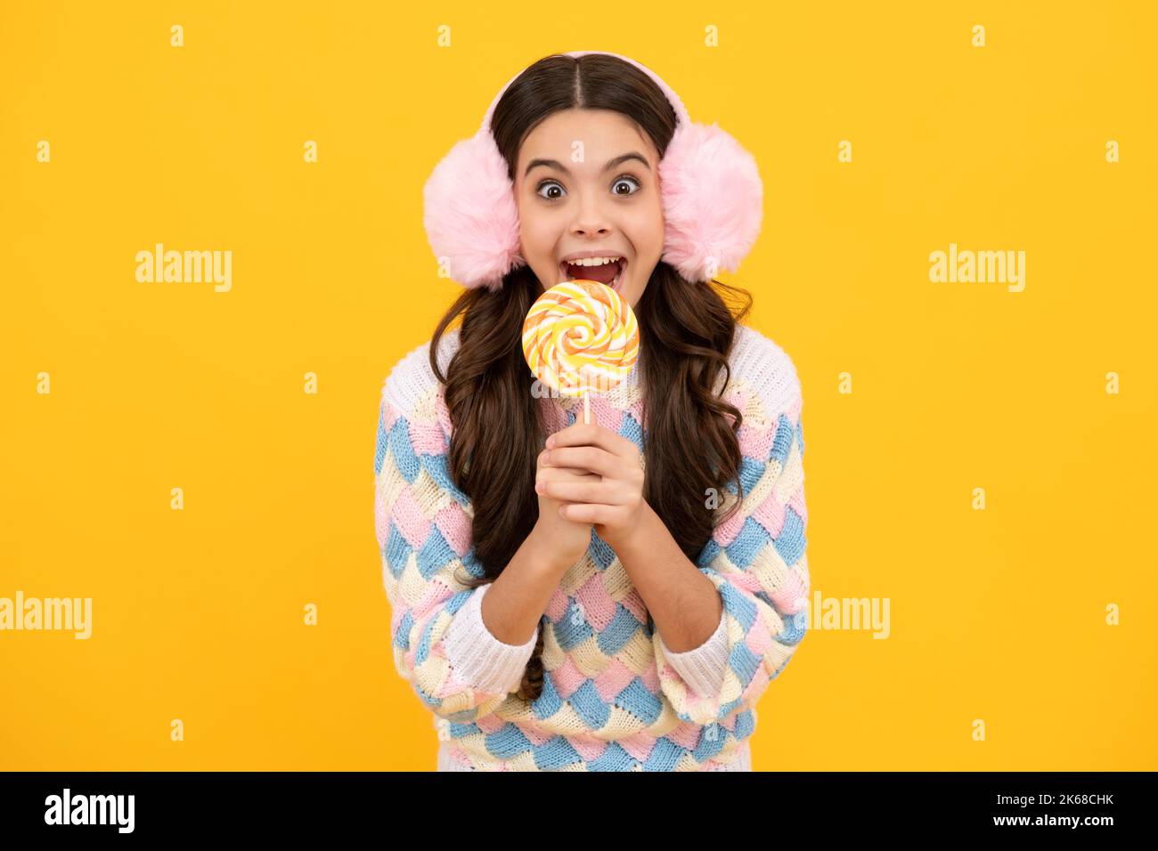 Cool teen child with lollipop over yellow isolated background. Sweet ...