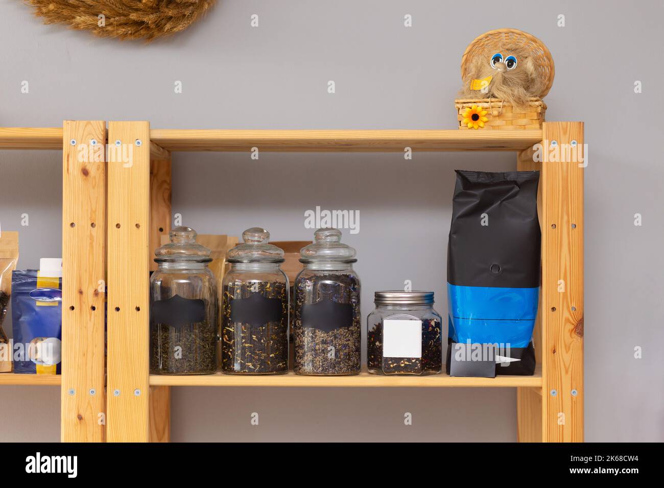 Assortment of different kinds of tea in glass jars, placed on shelf in ...
