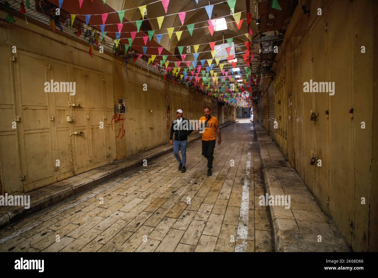 People walk past closed shops in the city of Nablus in the occupied ...