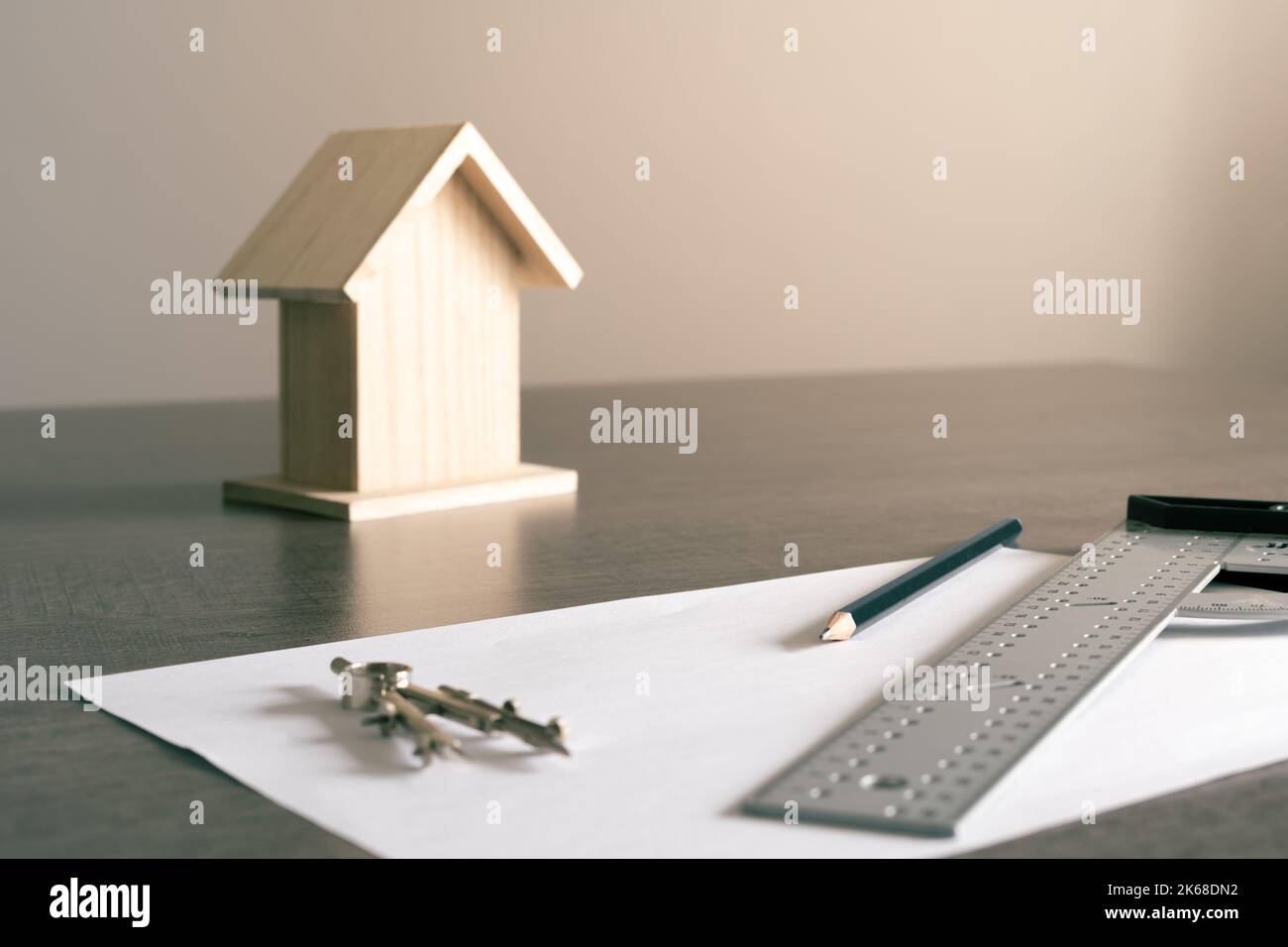 Objects on the table in an architect's office with a small wooden house ...
