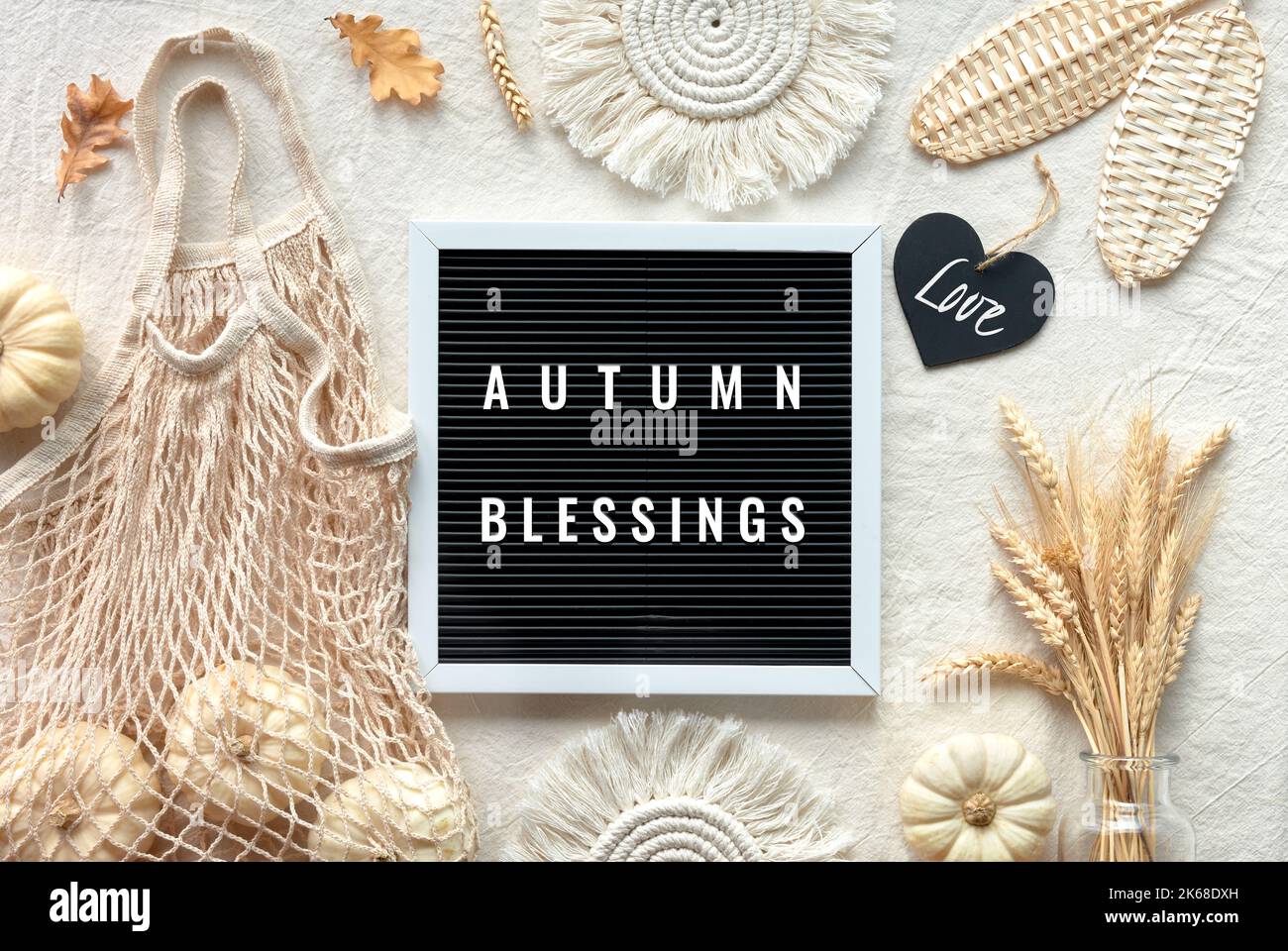 Off white textile background with natural Fall decorations. Text Autumn ...