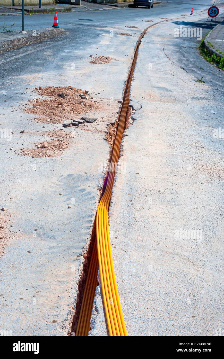 Worker inserts fiber optic cables buried in a micro trench Stock Photo ...