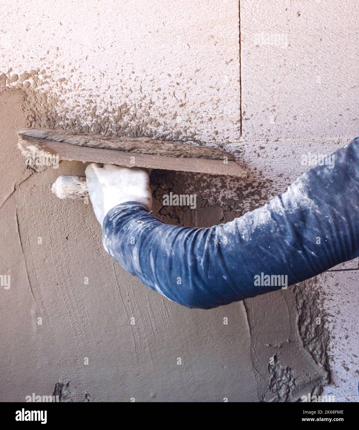Construction workers plaster the facade of the house. Worker plastering ...
