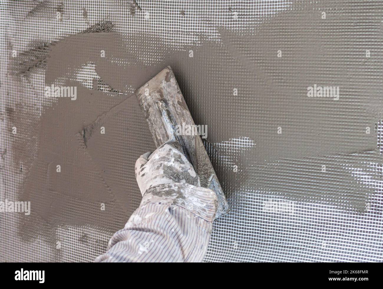 Construction workers plaster the facade of the house. Worker plastering ...