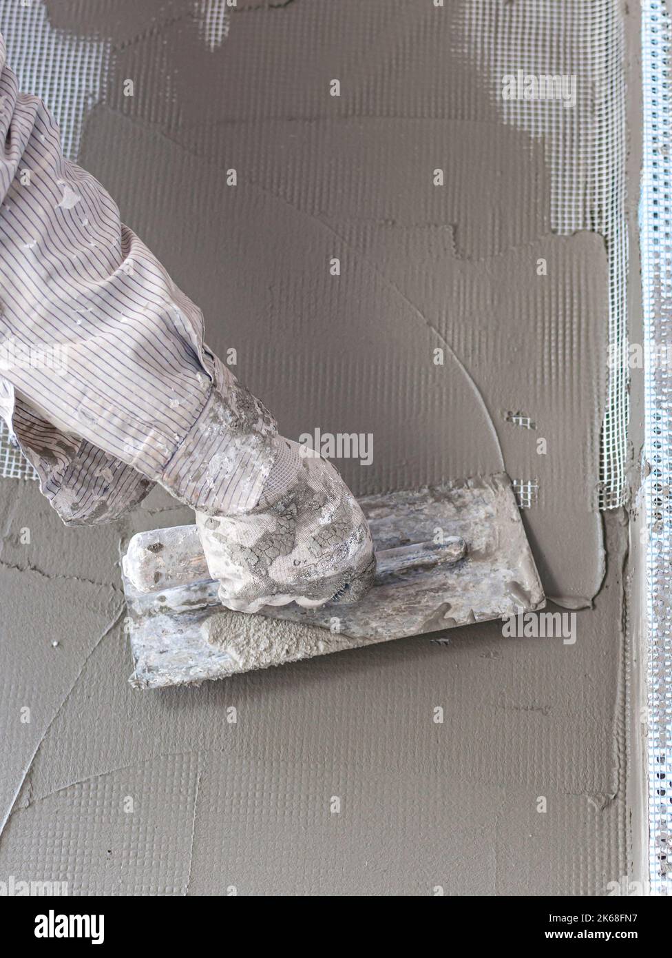 Construction workers plaster the facade of the house. Worker plastering ...