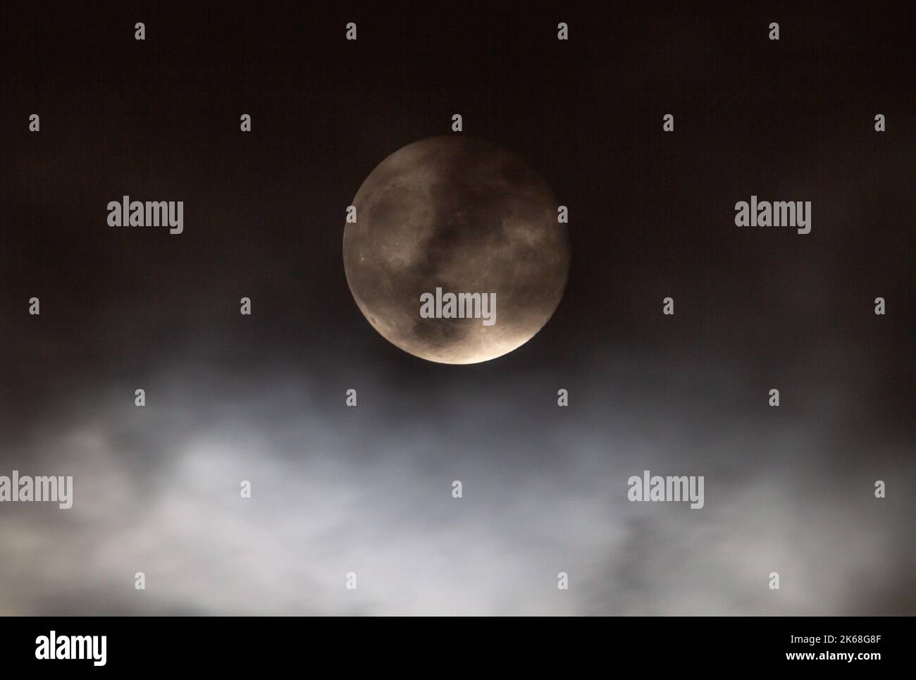 Ominous clouds pass in front of a full moon in the night sky Stock ...