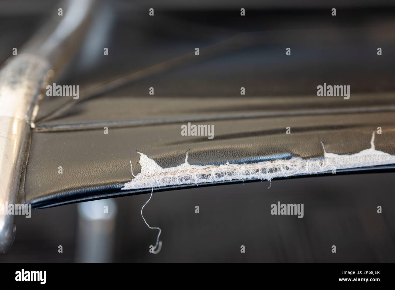 Selective focus on the a ripped and frayed polyester fabric cover for a ...