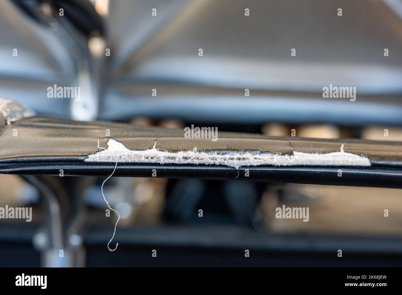 Selective focus on the a ripped and frayed polyester fabric cover for a ...