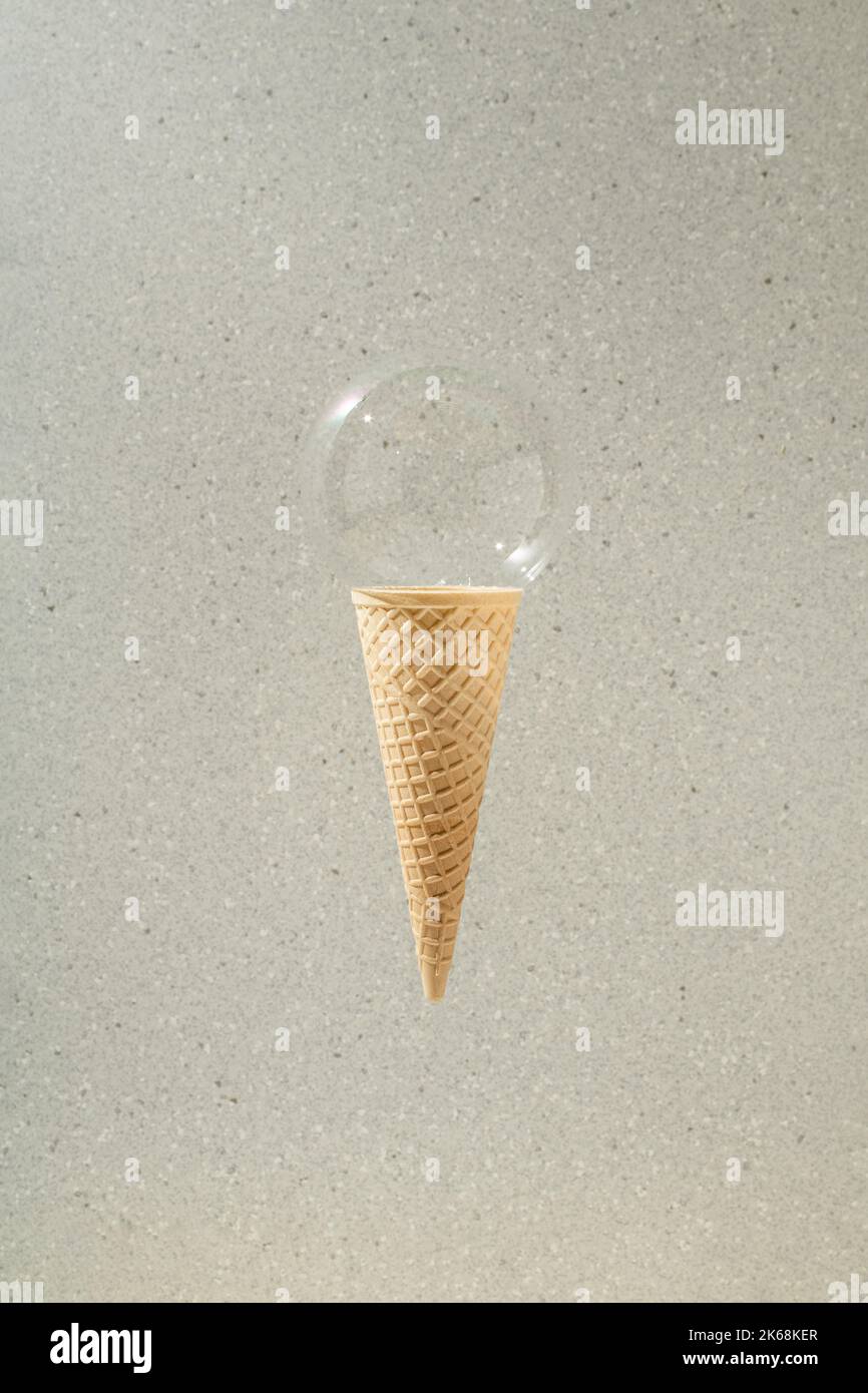 Soap bubble in ice cream cone levitating against stone background ...