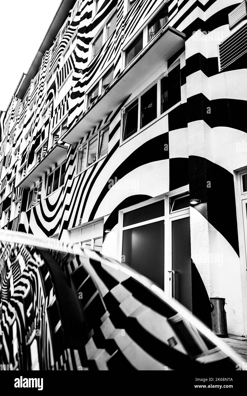 A vertical grayscale shot of an abstract building facade painted in ...