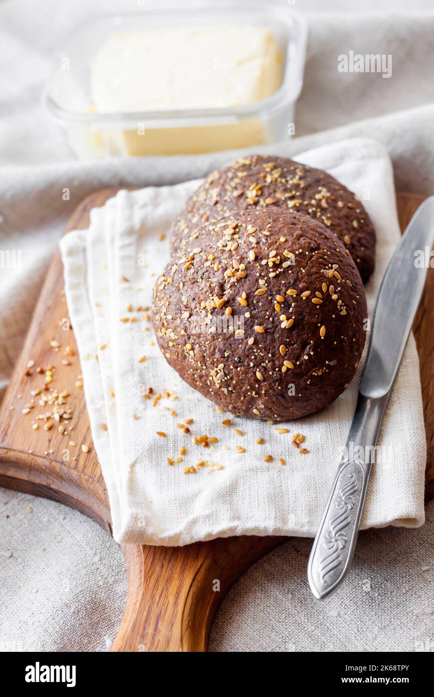 Homemade rye buns with linseeds, sesame and white poppy seeds on wooden ...