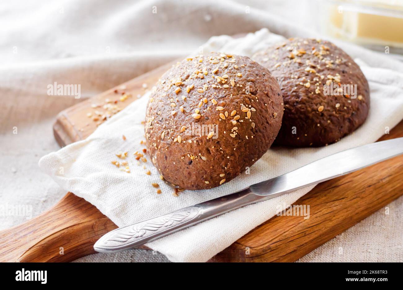 Homemade rye buns with linseeds, sesame and white poppy seeds on wooden ...