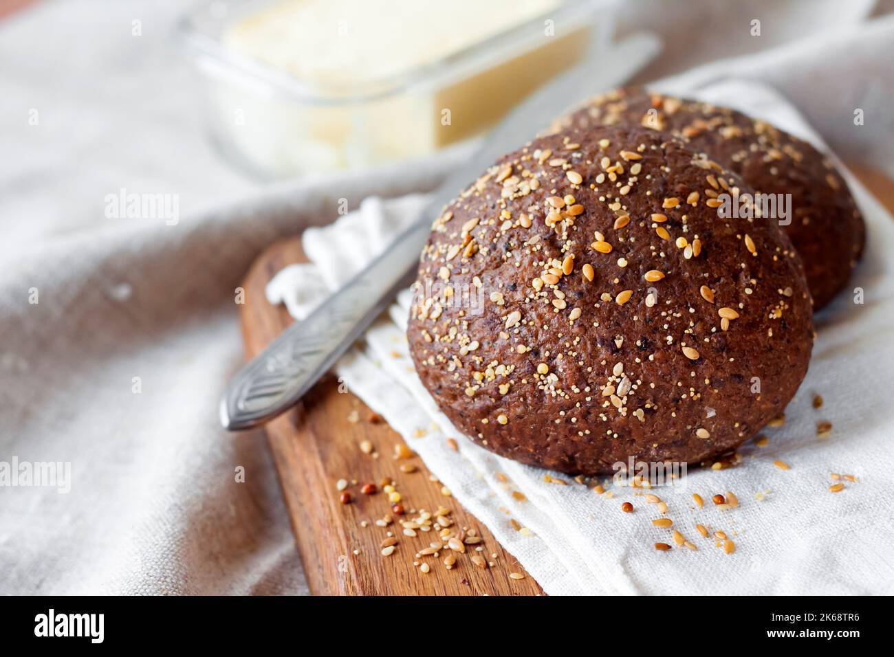 Homemade rye buns with linseeds, sesame and white poppy seeds on wooden ...