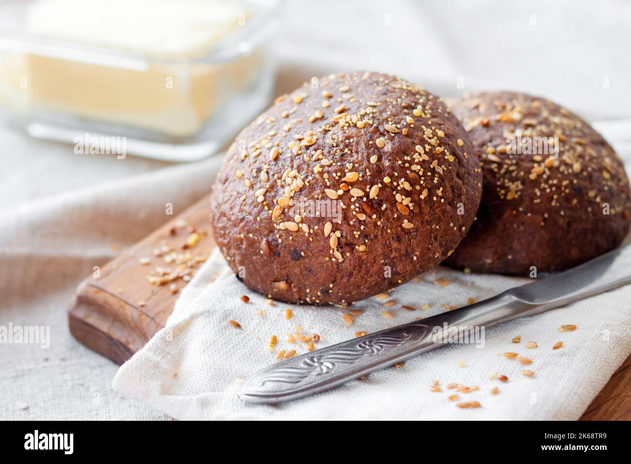 Homemade rye buns with linseeds, sesame and white poppy seeds on wooden ...