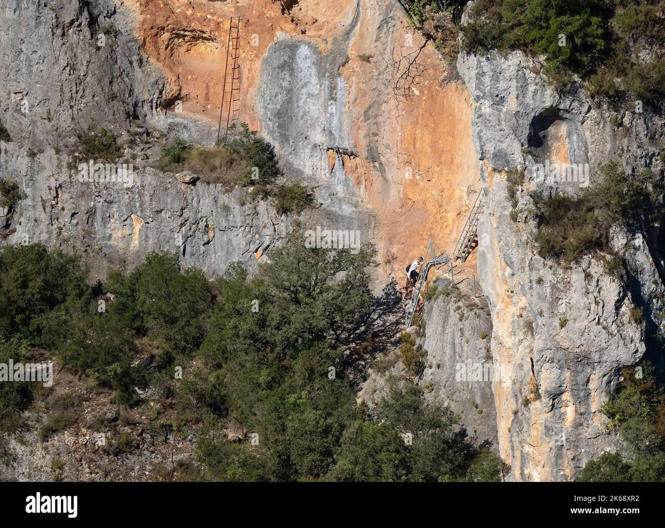two people exploring the rocky outcrops and caves that are home to ...