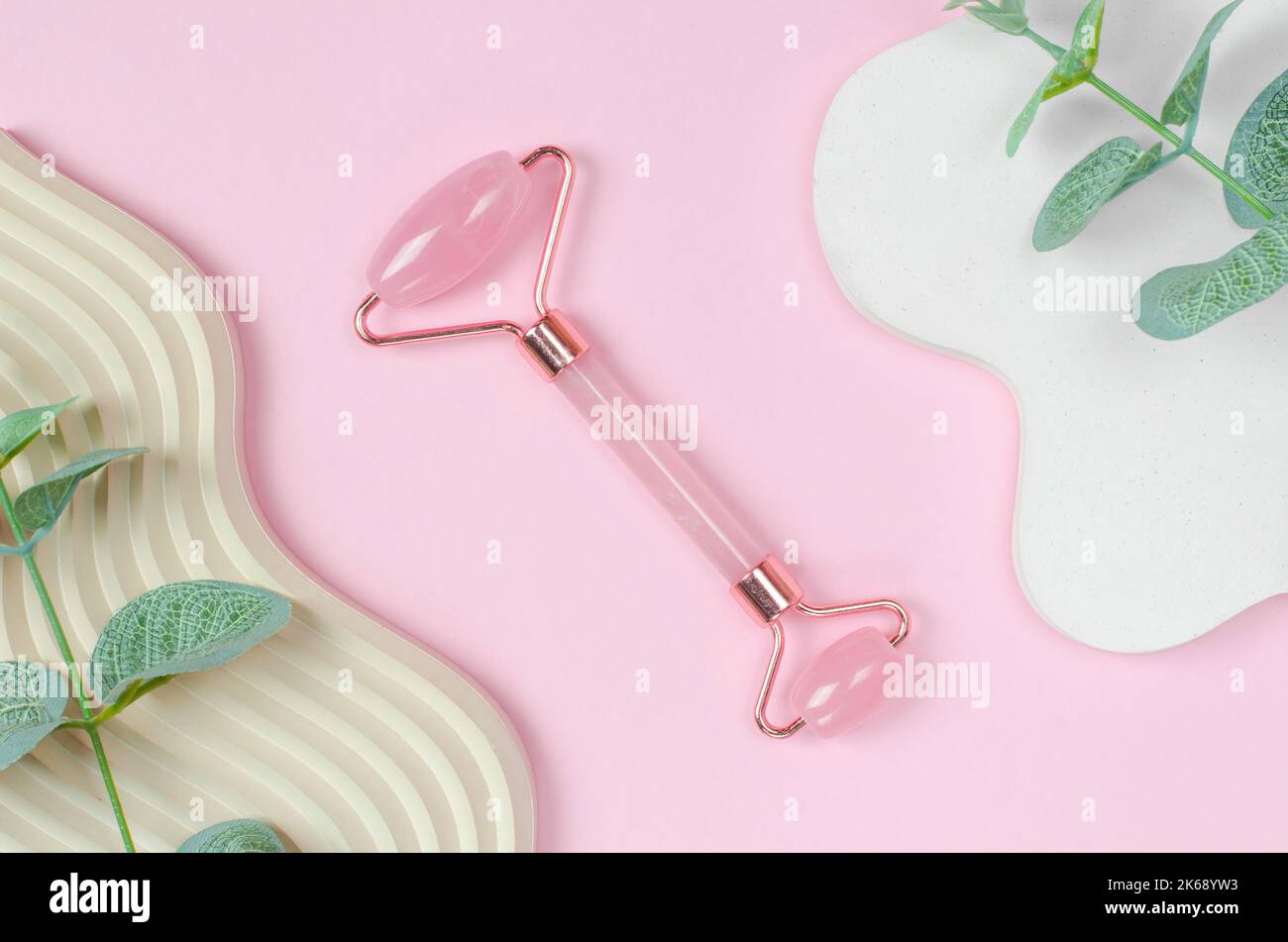 Roller jade facial massager on pink background with geometric shapes ...
