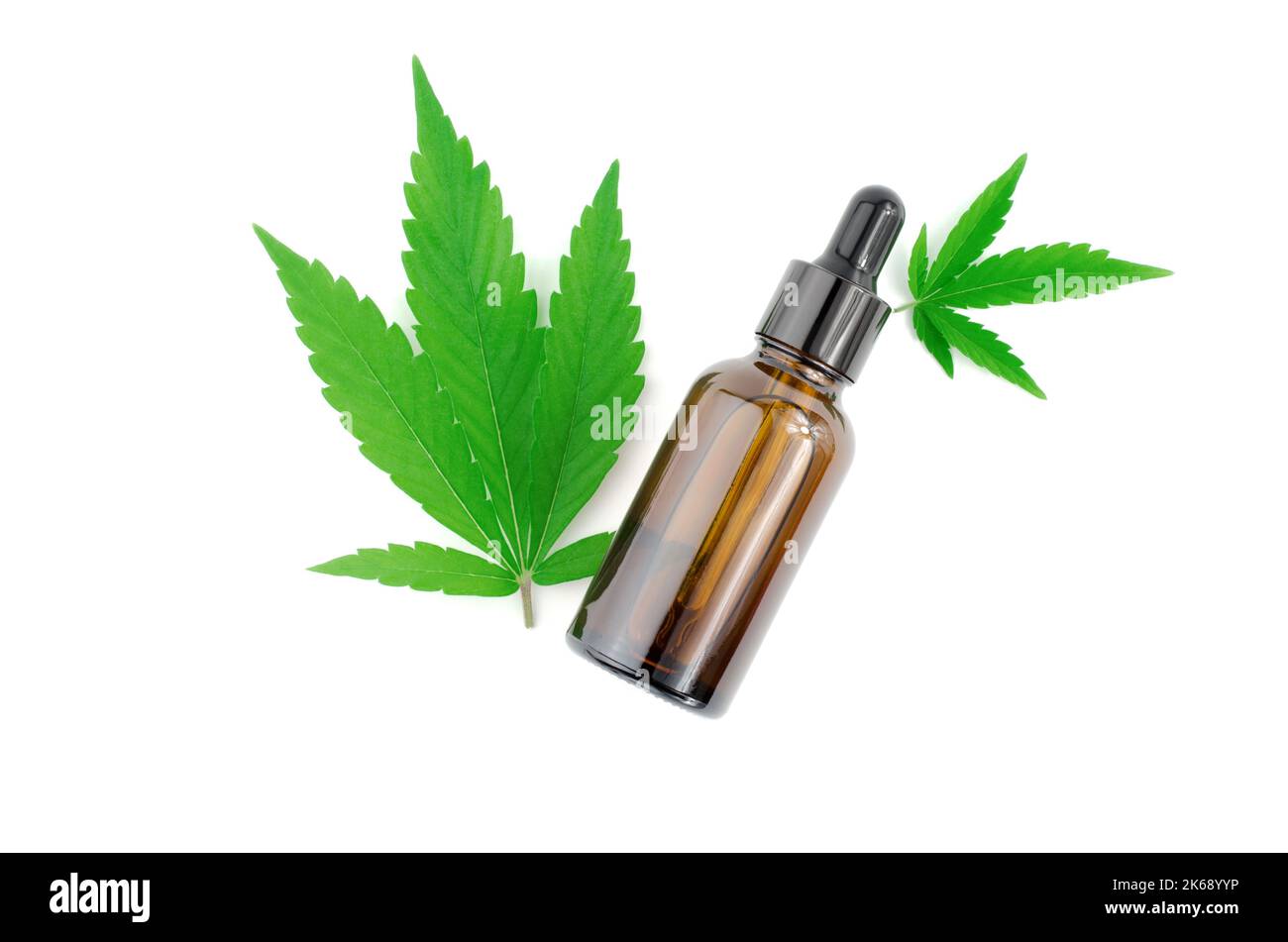 A bottle with a pipette and hemp leaves on a white background. Natural ...